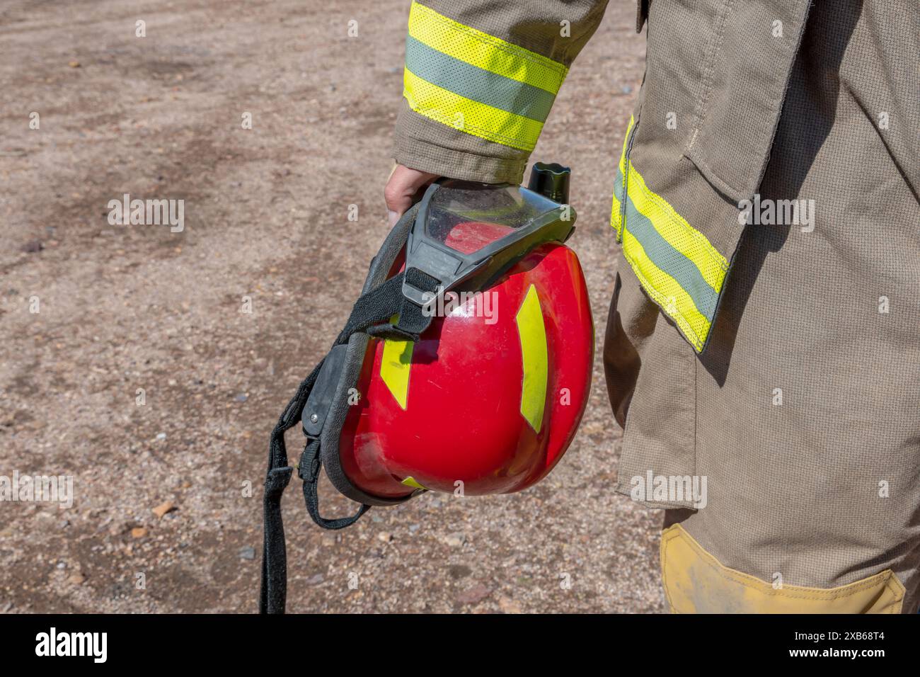 firefighter holding red safety helmet. Horizontal photo Stock Photo - Alamy