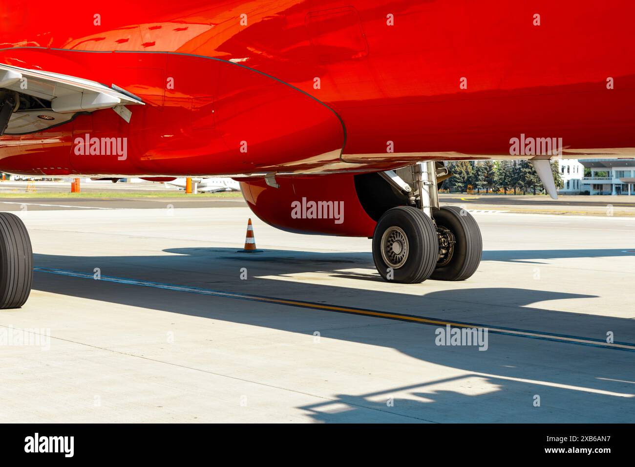 Red airplane with wheels on the ground, seen on the runway Stock Photo ...