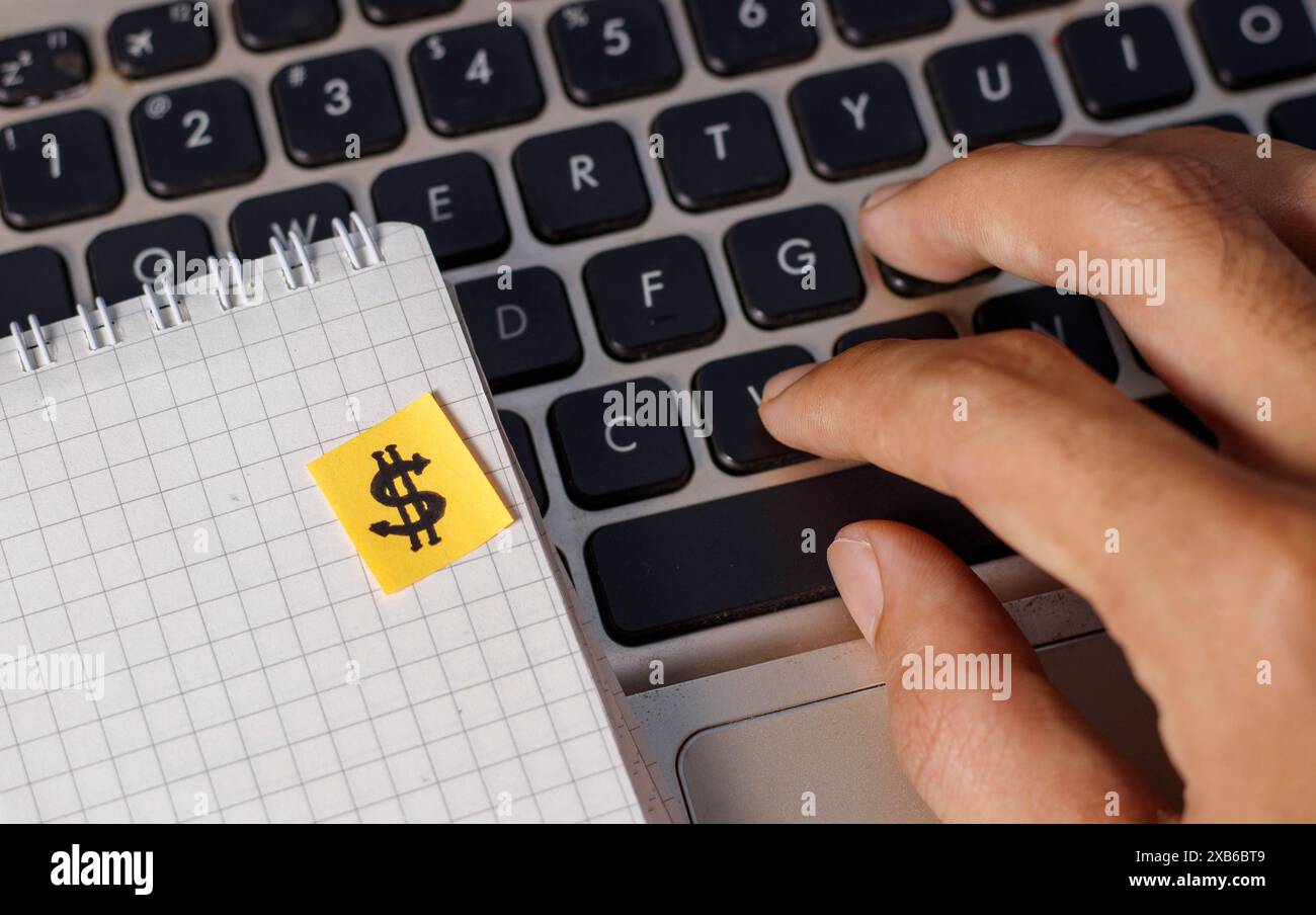 Laptop keyboard background with sticky notes depicting the dollar logo ...