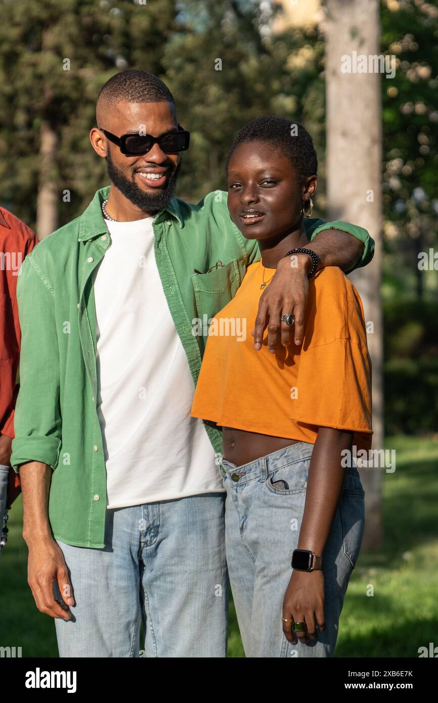 Happy african american guy student smiling hugging girlfriend standing ...