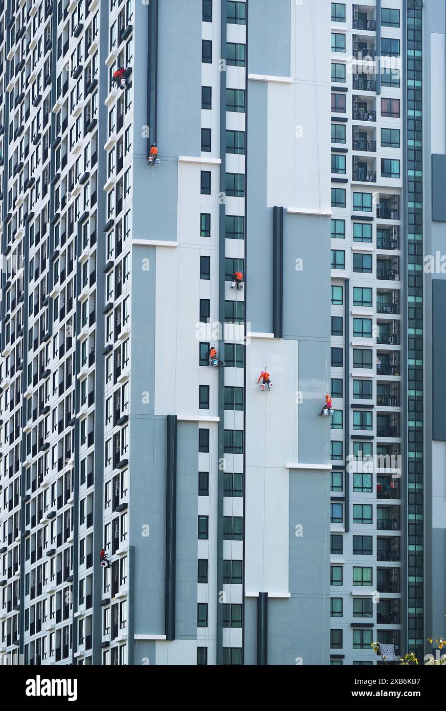 Group of industrial climbing workers painting the facade of a high ...