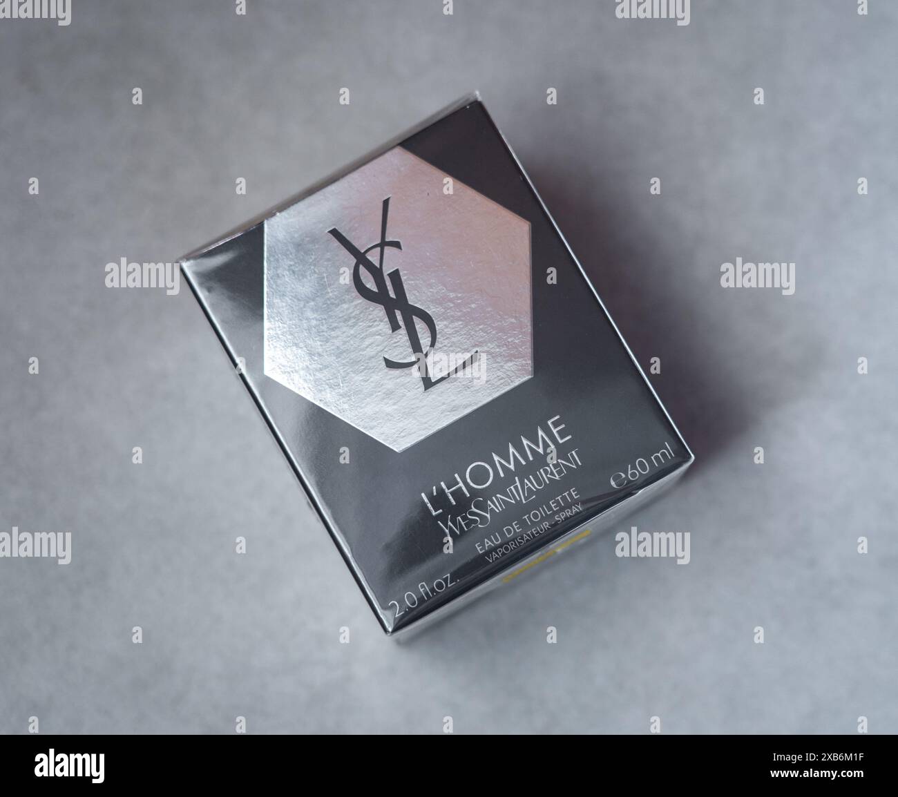 A sealed box of Yves Saint Laurent L'Homme on grey tile background ...