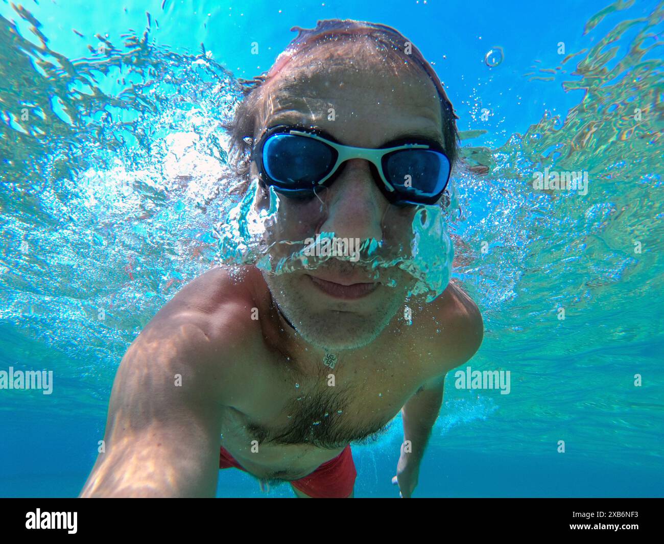 Funny guy having fun and taking underwater selfie while swimming in the ...