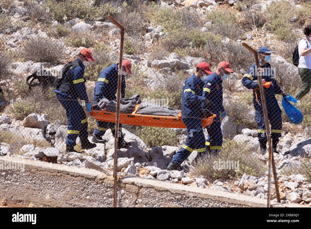 Greek Fire Services officers carrying away on a stretcher the body of ...