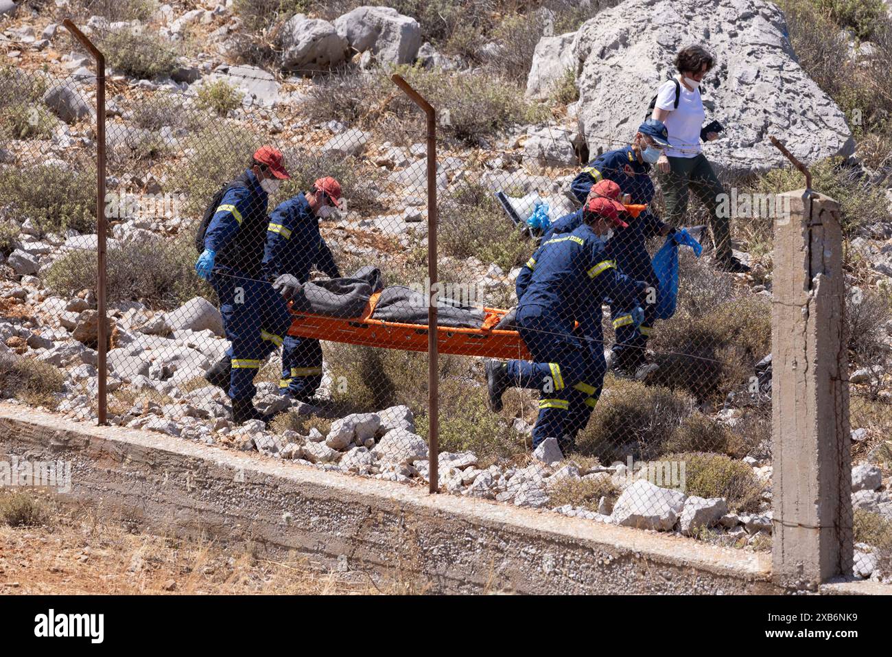 Greek Fire Services officers carrying away on a stretcher the body of ...