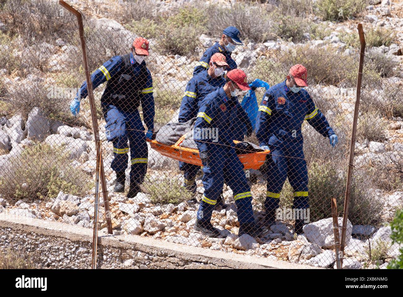 Greek Fire Services officers carrying away on a stretcher the body of ...