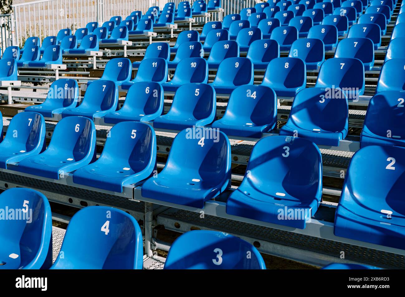 Numbered rows of blue seats are arranged in tiers throughout the ...