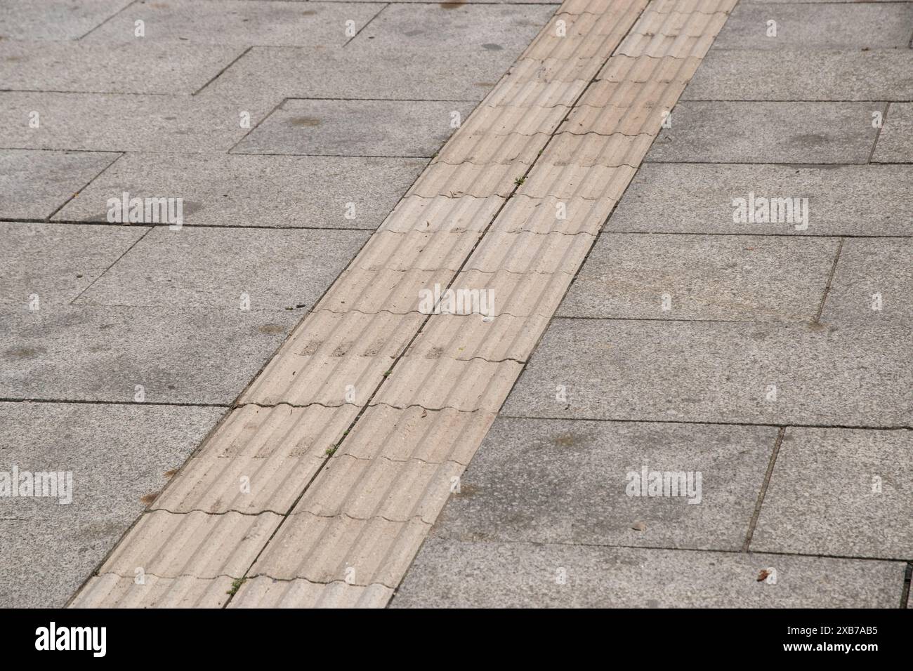 Line of special tiles on footpath designed for use by blind people ...