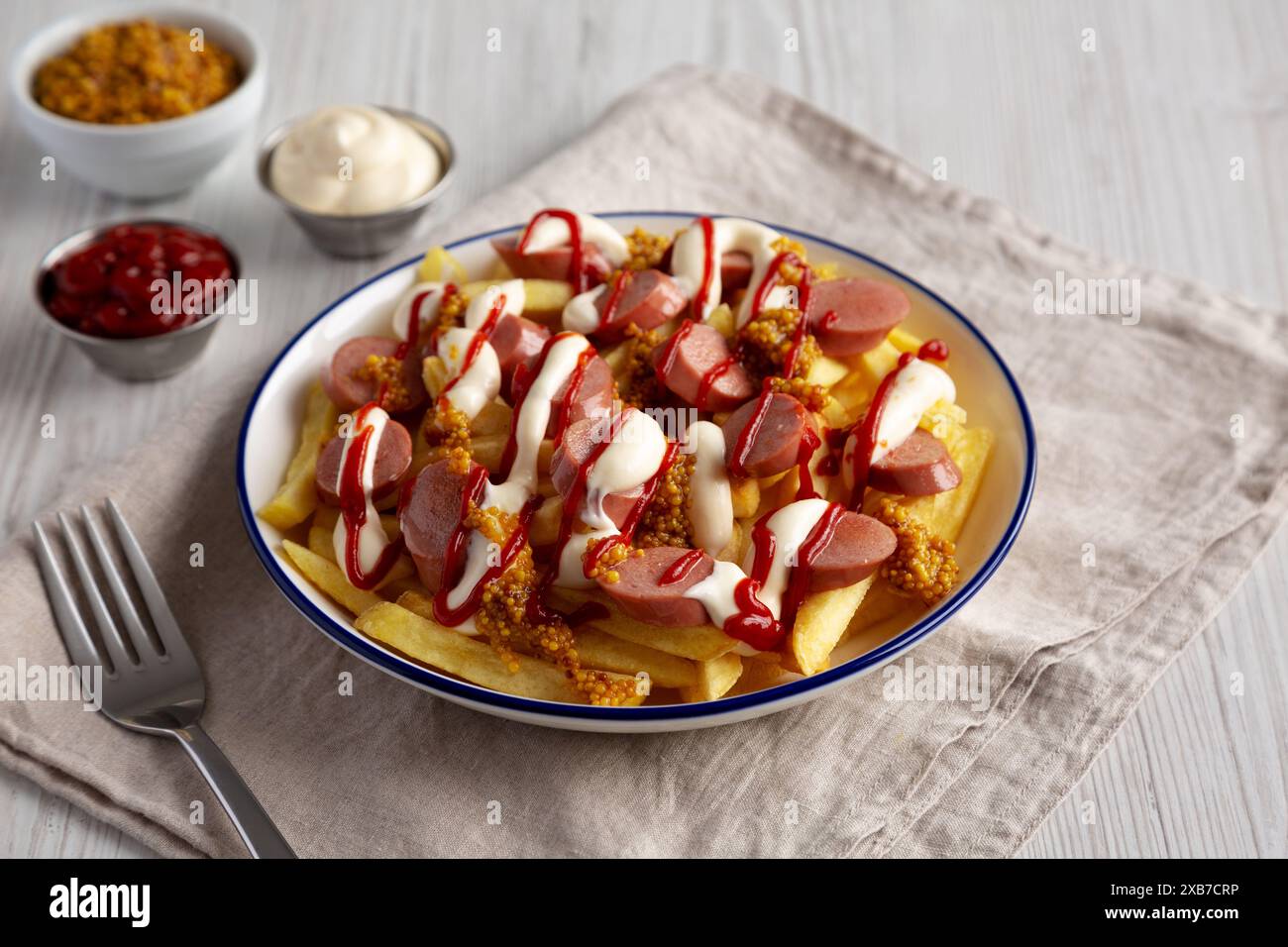 Homemade Salchipapa Fries with Ketchup, Mustard and Mayo on a Plate ...