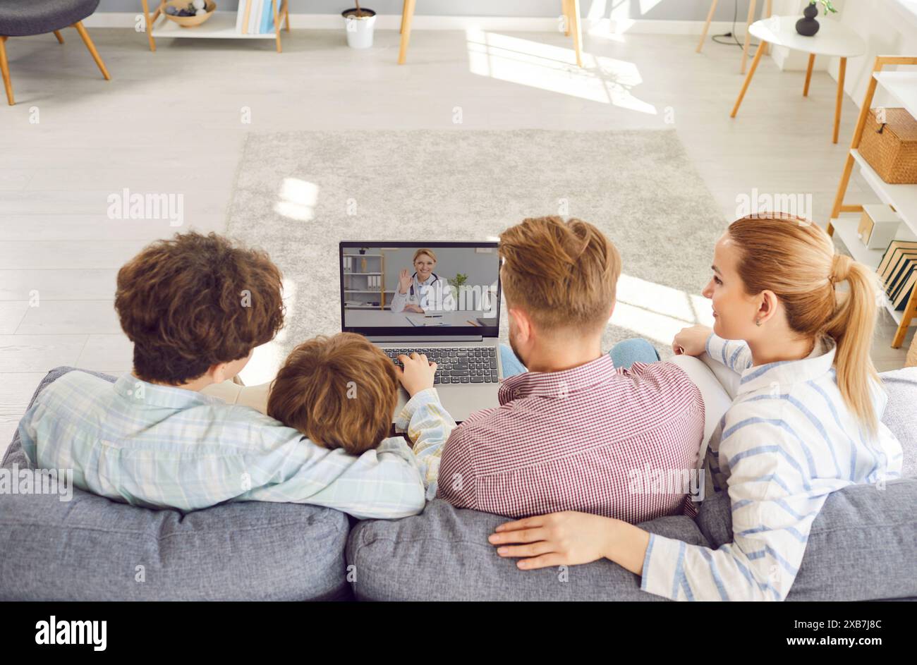 Family With Children Having Online Video Call With Doctor Or Nurse At ...