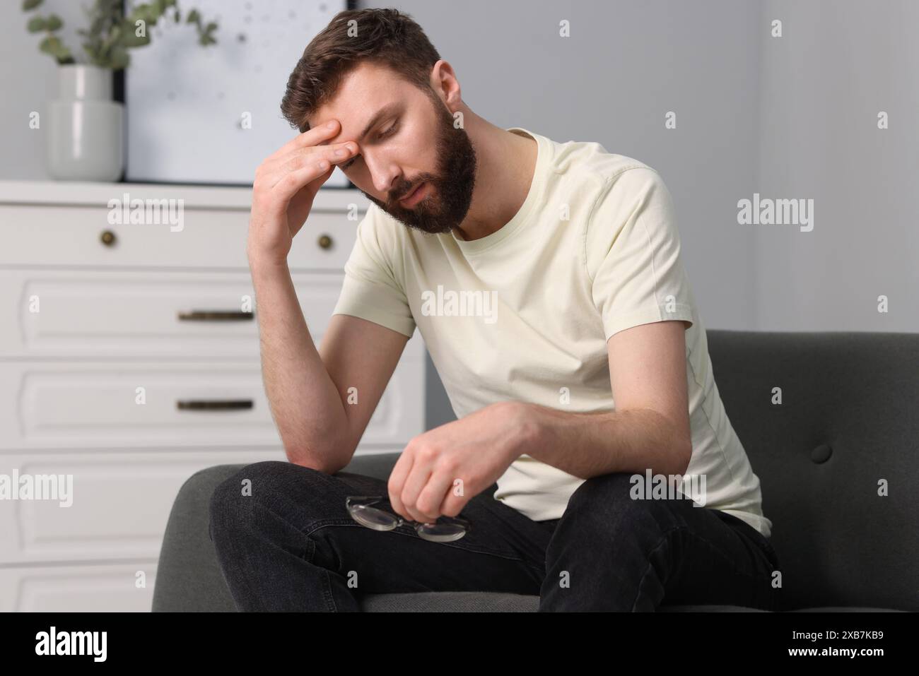 Overwhelmed man with glasses suffering at home Stock Photo - Alamy