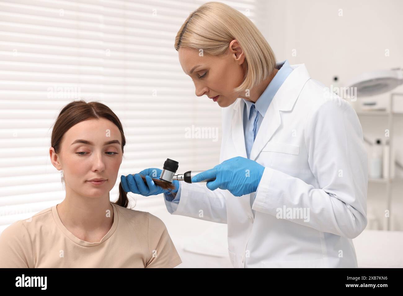 Trichologist with dermatoscope examining patient`s hair in clinic Stock ...