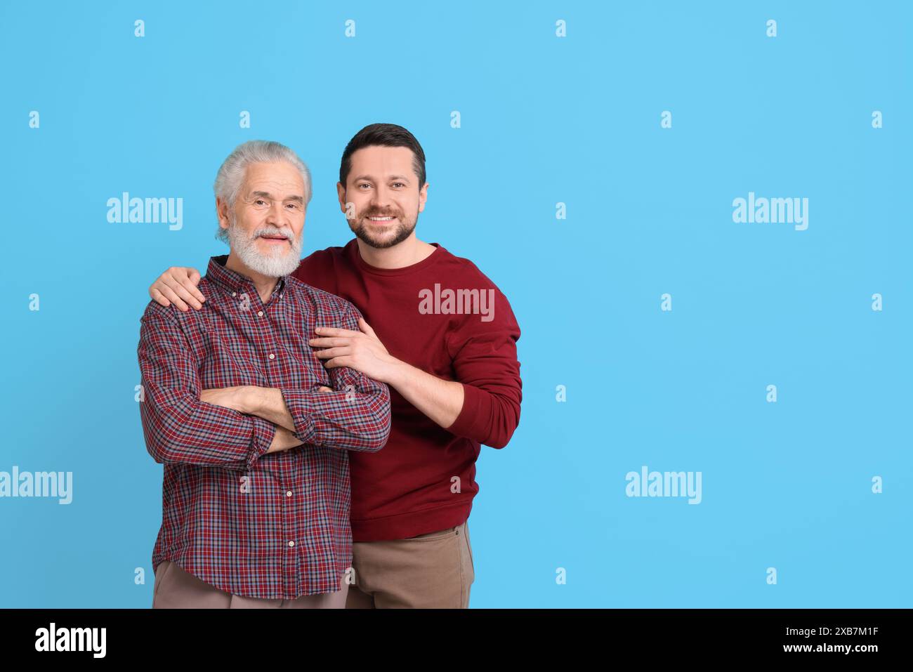 Happy son and his dad on light blue background, space for text Stock ...