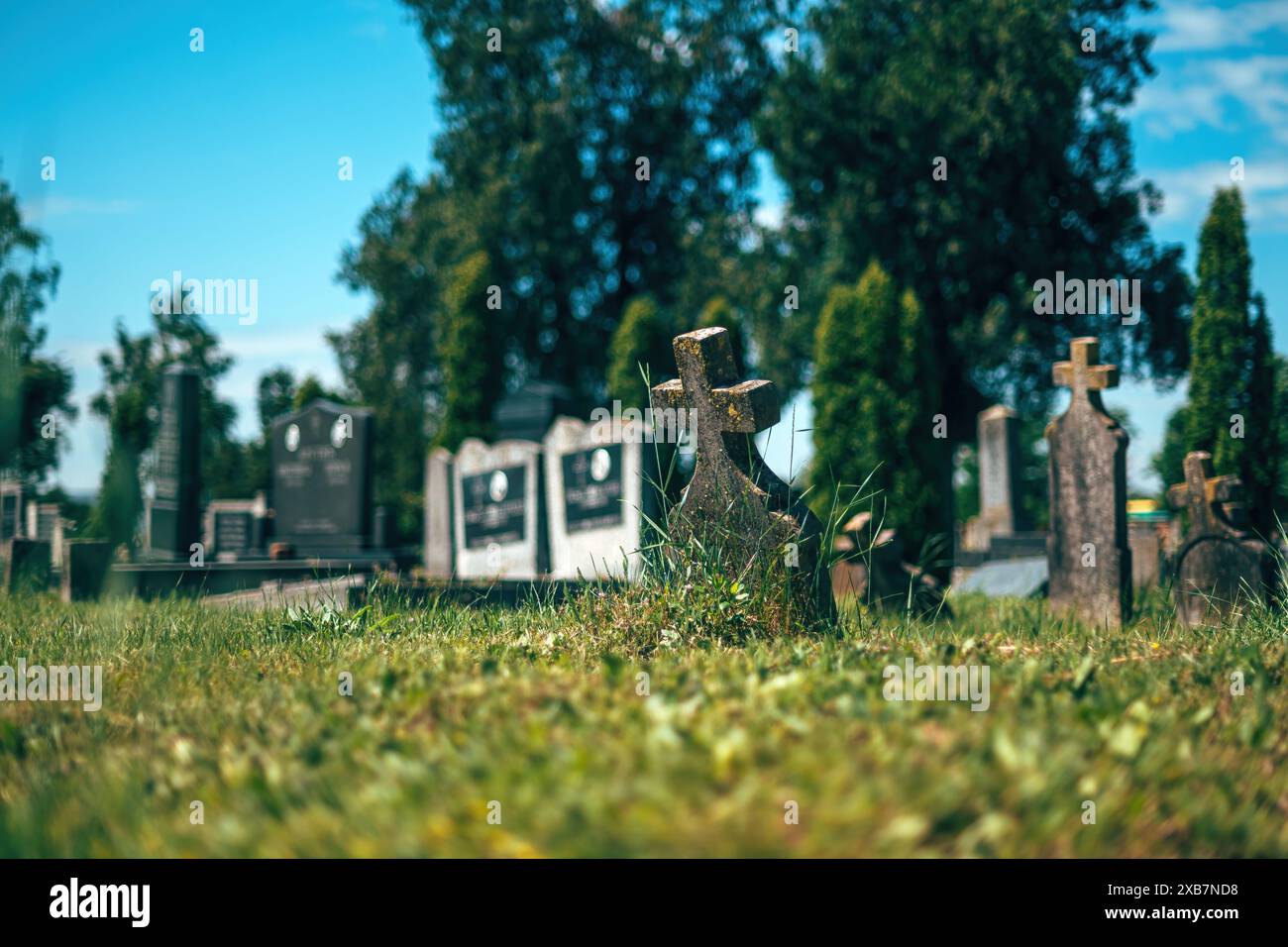 Old concrete christian cross tombstone on a graveyard burial ground ...