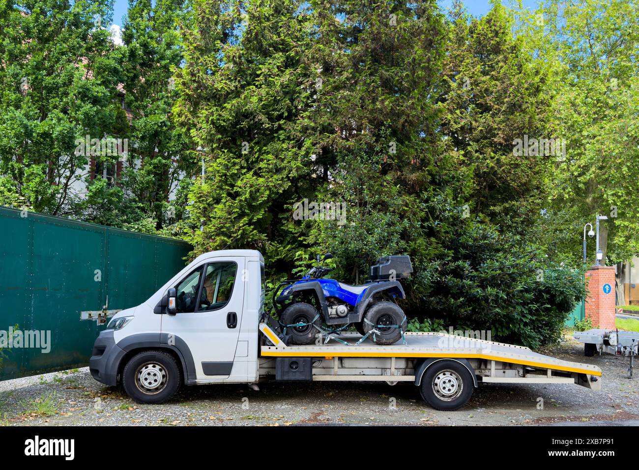 A blue ATV quad bike loaded into the back of a small car Stock Photo ...