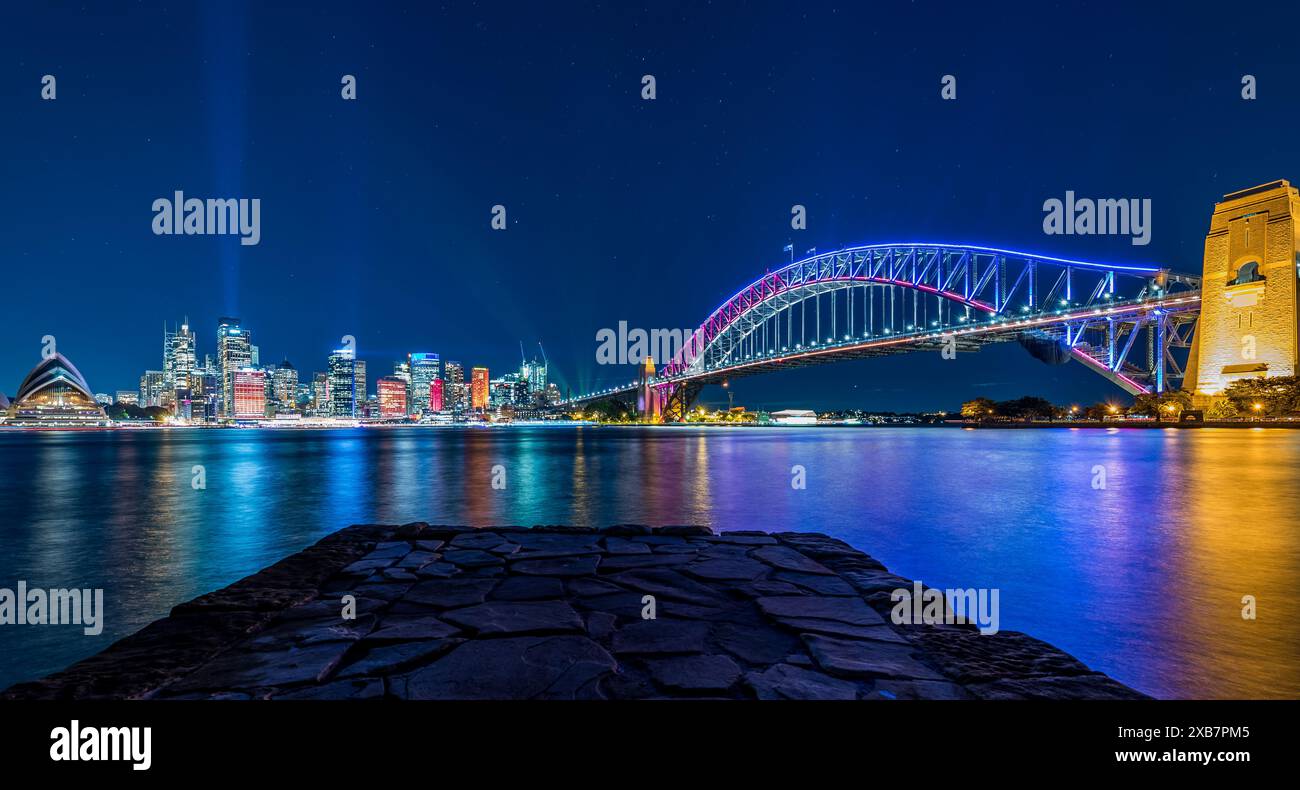 The Sydney city lights and Opera House bridge at night during the light ...