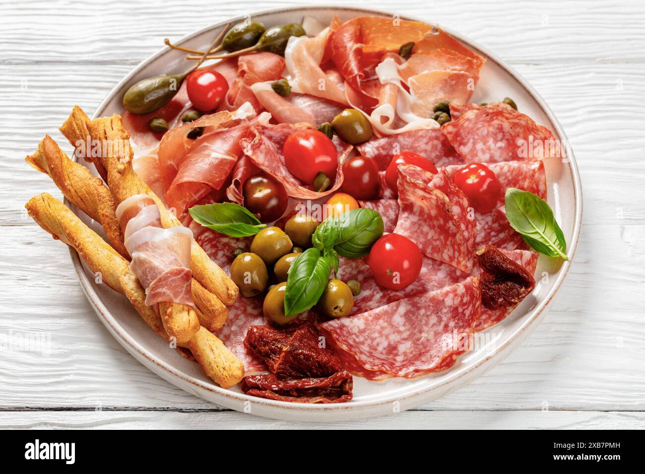italian antipasto platter of salami slices, parma ham, grissini ...