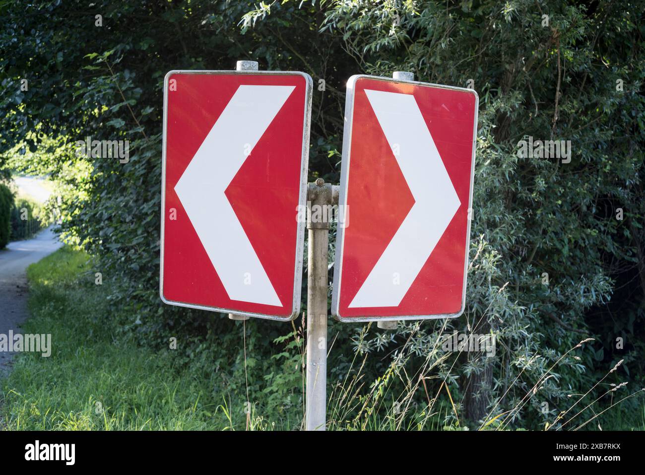 A shot of two red and white directional signs with arrows in opposite ...