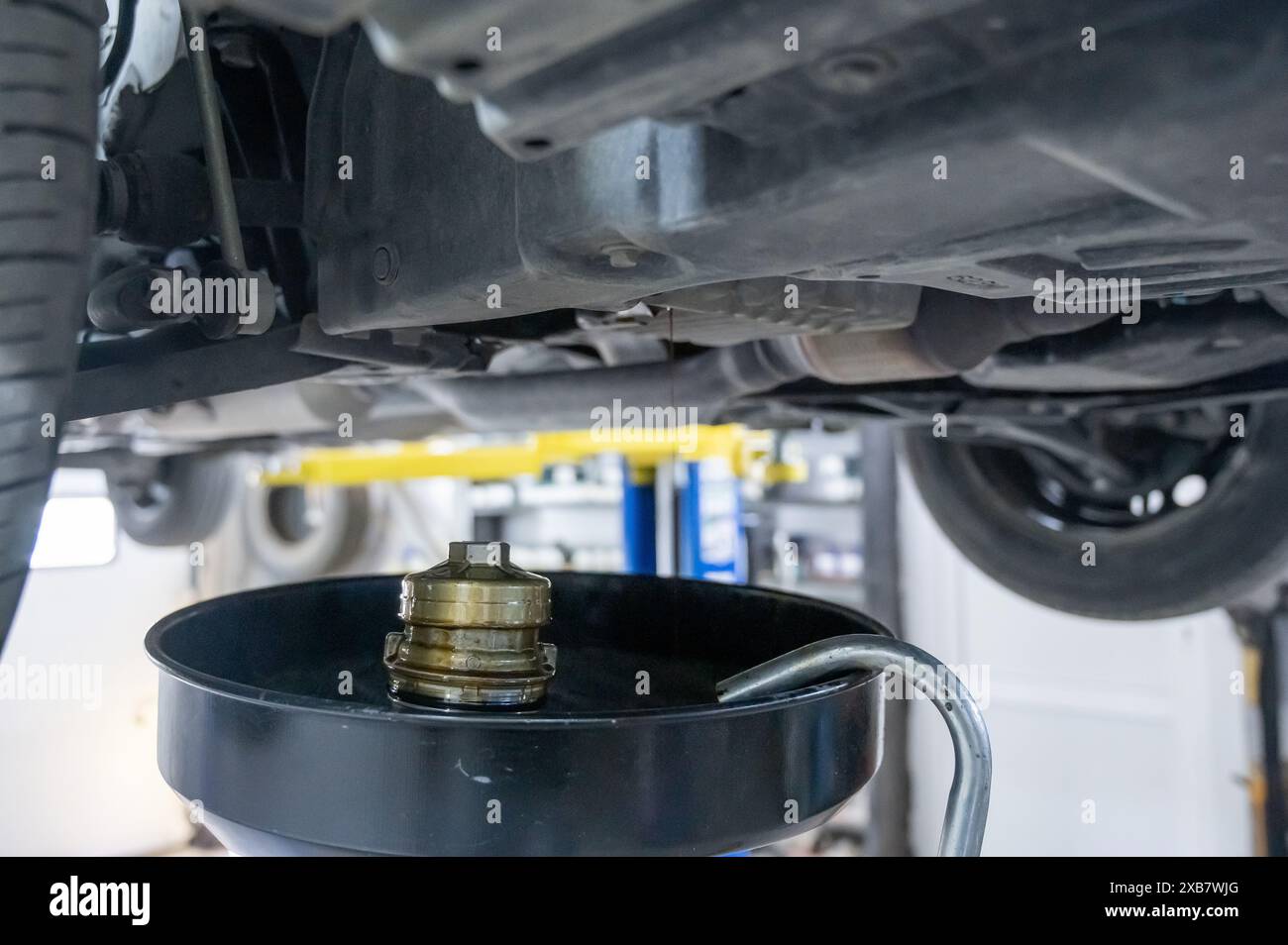 A mechanic drains a car's used engine oil Stock Photo - Alamy