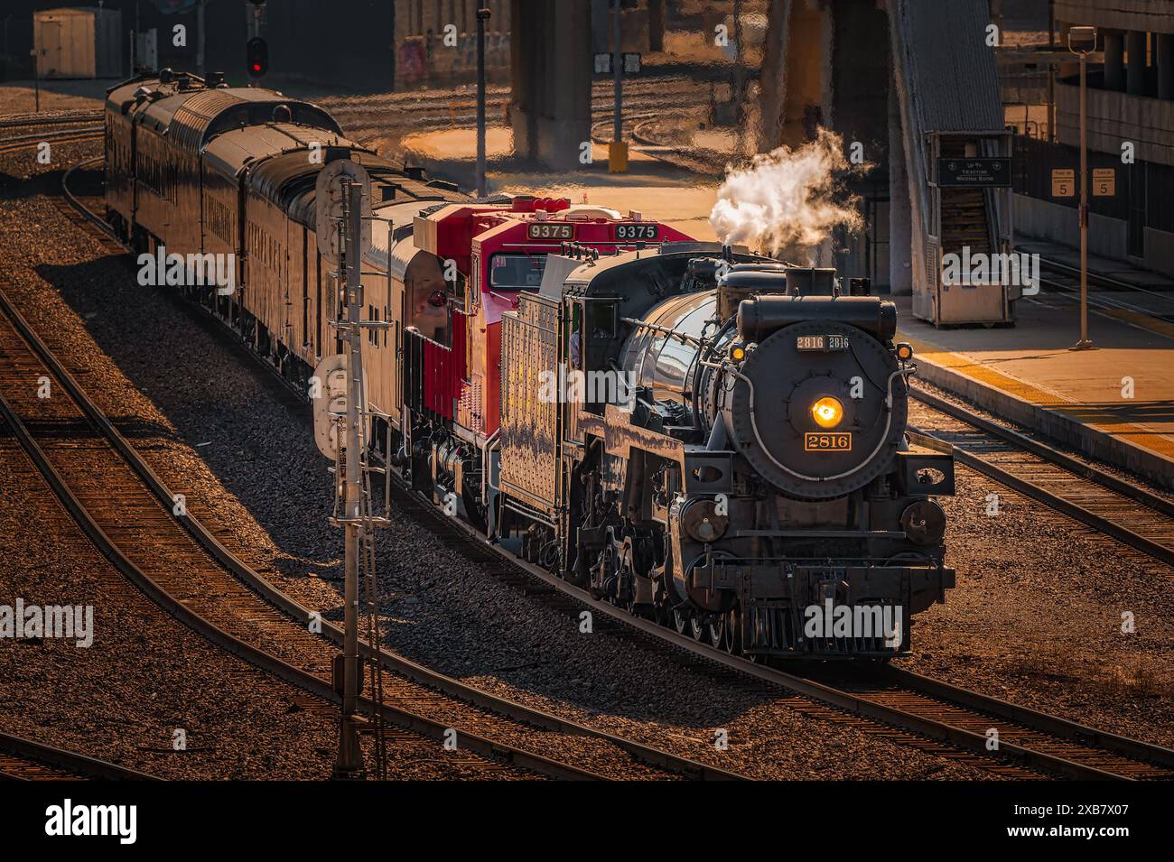 A train approaches the station on the tracks Stock Photo - Alamy