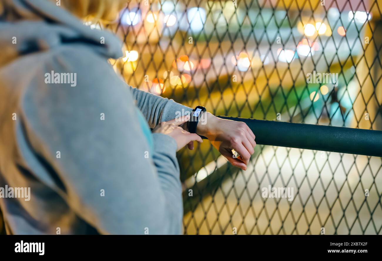 Close up of unrecognizable female hand touching digital wrist band ...