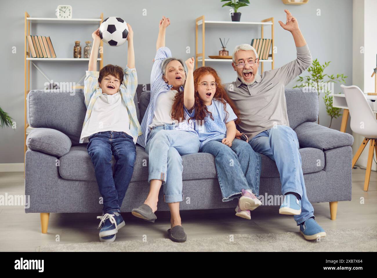 Excited happy family grandparents and children fans watching sport ...