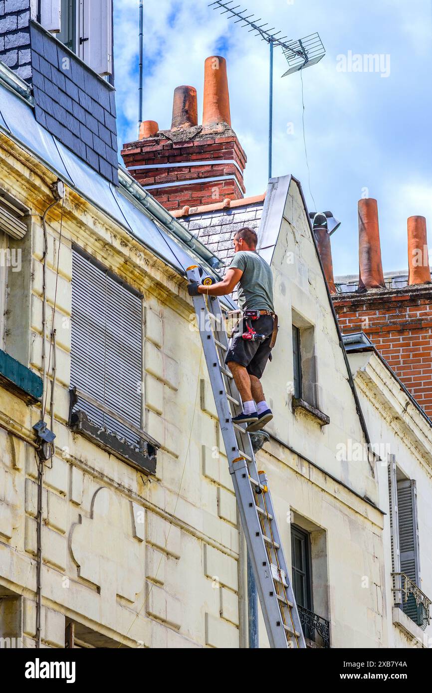 Workman (with no safety equipment) scaling tall rope-operated triple ...