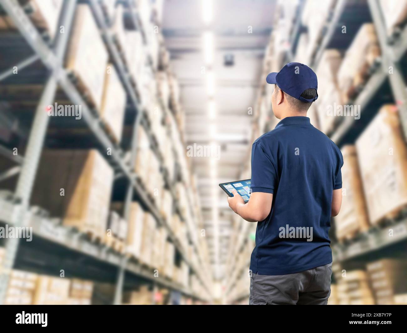 Asian worker or engineer in warehouse with stack of cardboard boxes ...