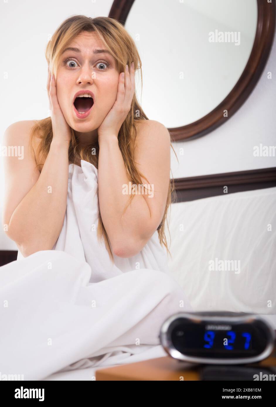 Woman in panic looks at clock Stock Photo - Alamy