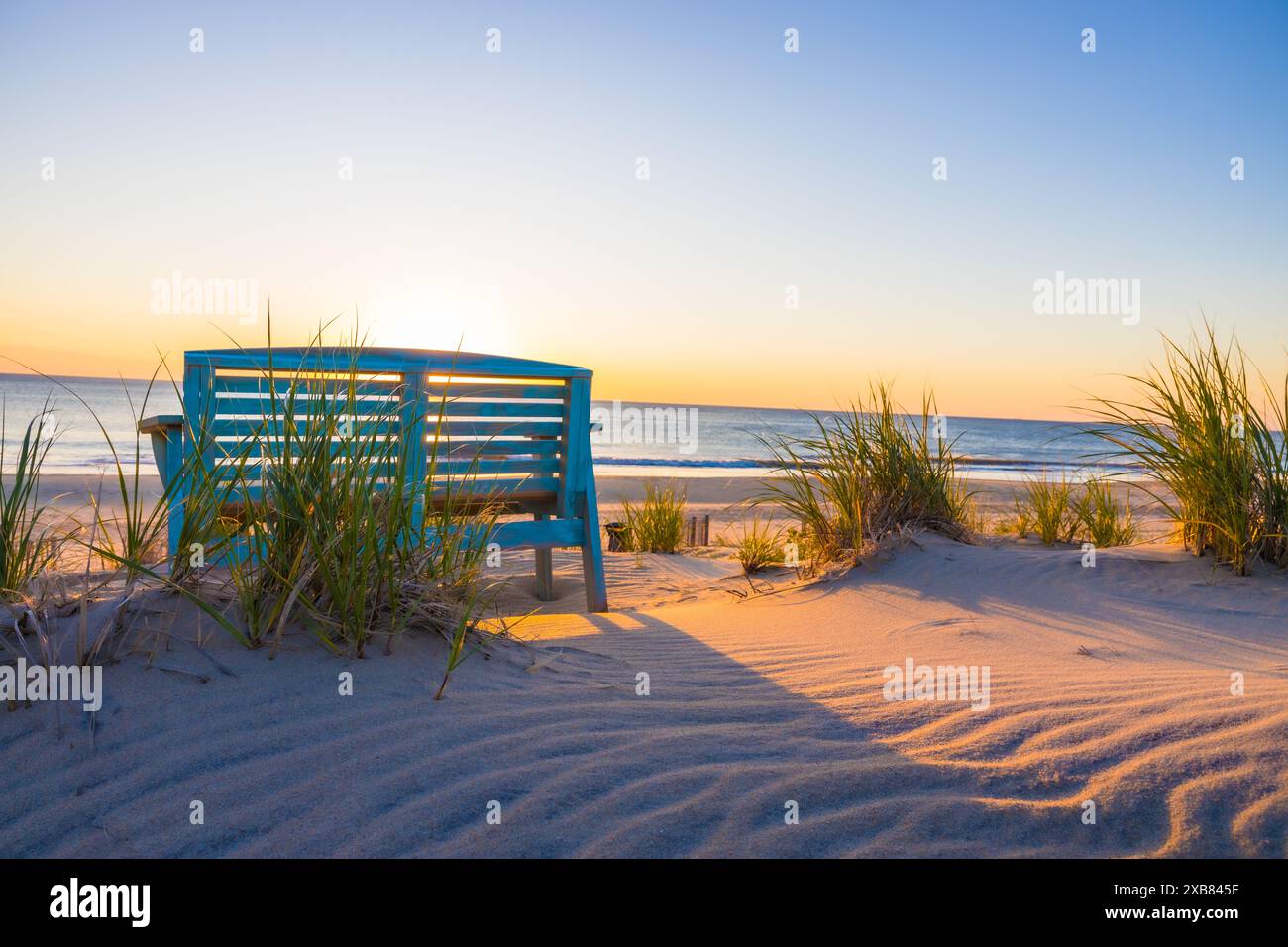 Blue bench by sandy beach with sea grasses in Nags Head, North Carolina ...