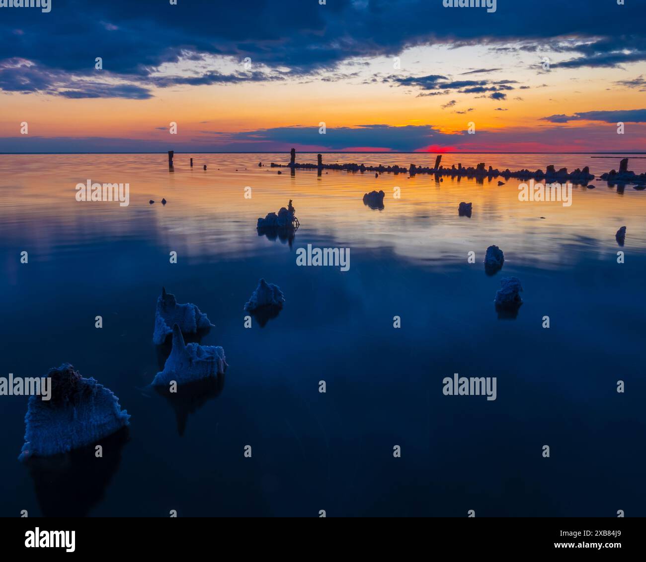 A tranquil sunset scene with vibrant colors reflecting on calm water ...