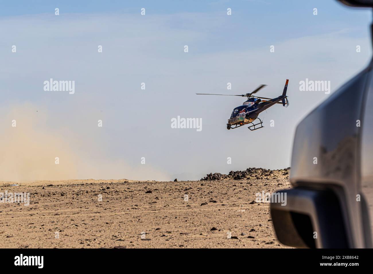 Helicopter in flight over dirt field Stock Photo - Alamy