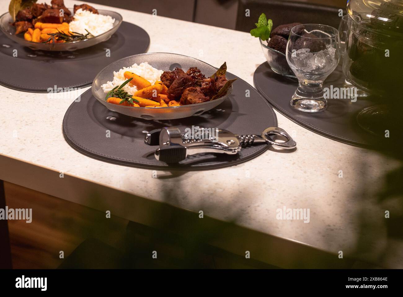 Two dishes on white countertop near glass bottle Stock Photo - Alamy