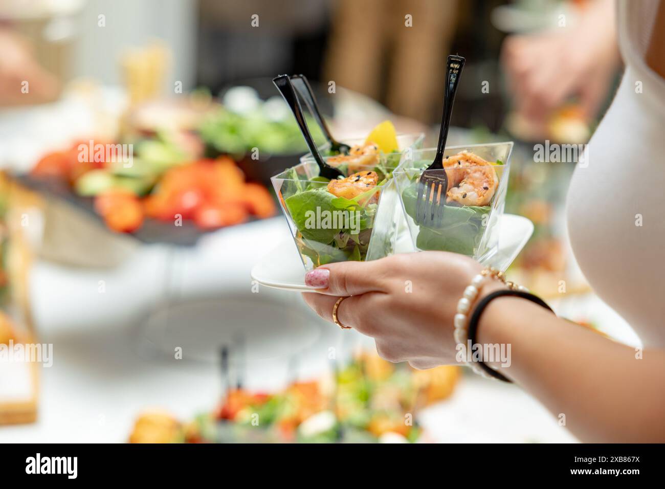 catering. Hands putting salad with shrimp on a plate,Hand held ...