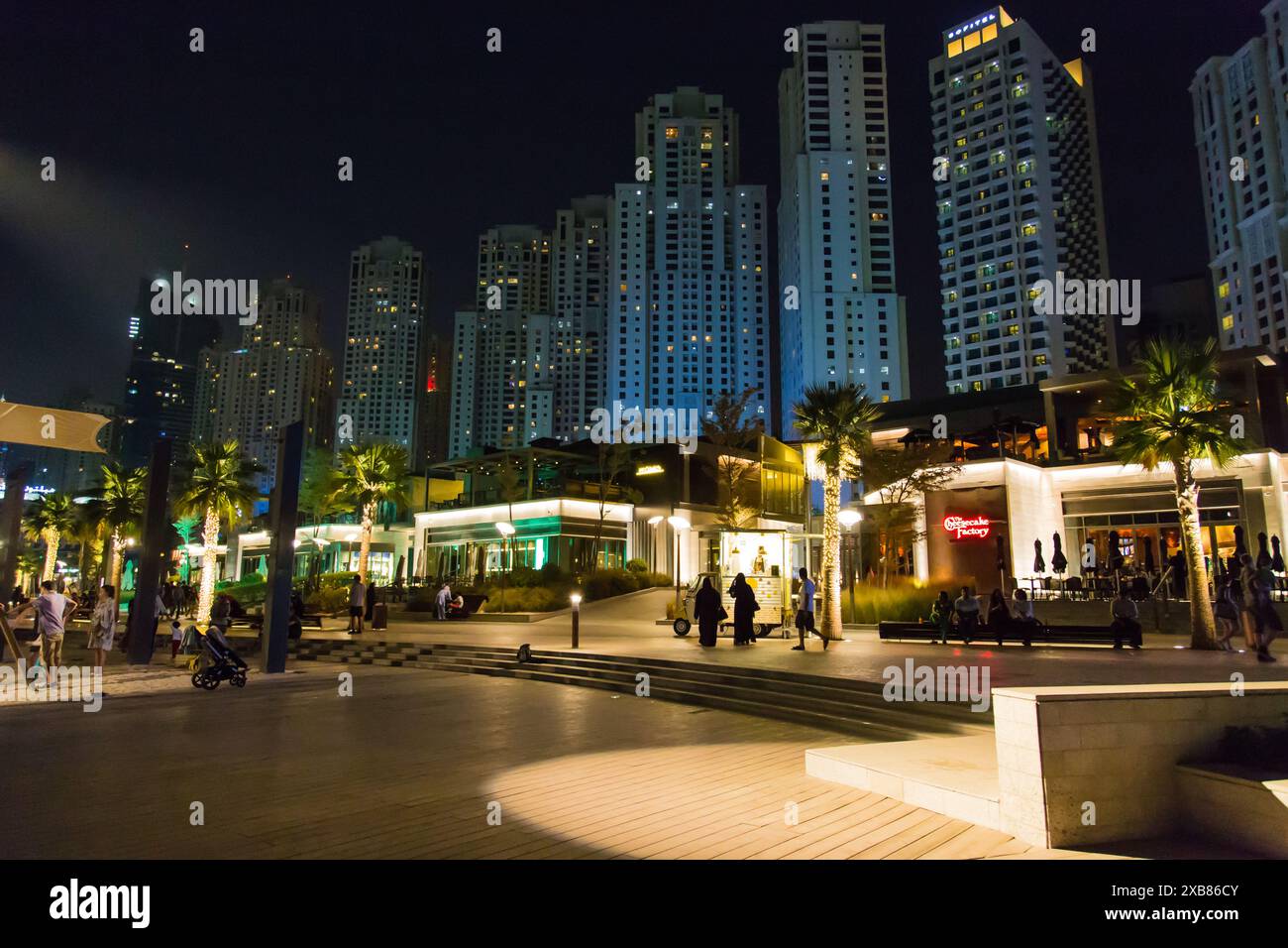Urban cityscape at night with illuminated buildings and a bus located ...