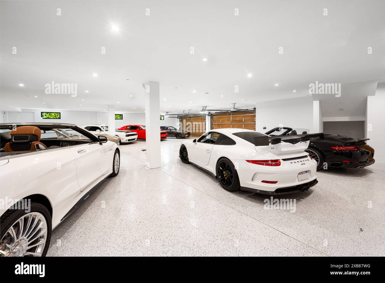 Multiple luxurious vehicles parked inside a white-wall room Stock Photo ...