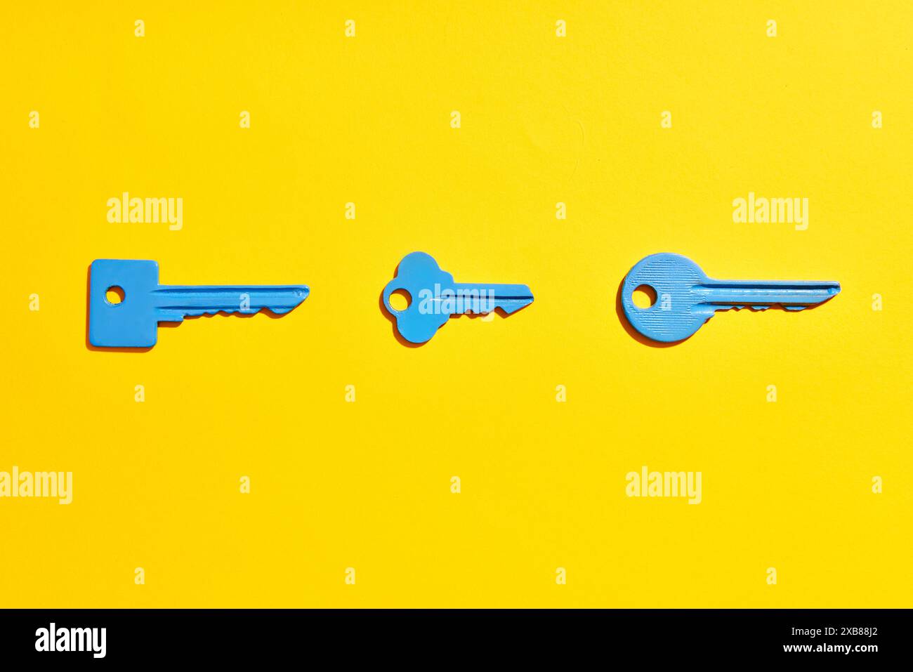 Blue keys on vibrant yellow background. Flat lay Stock Photo - Alamy