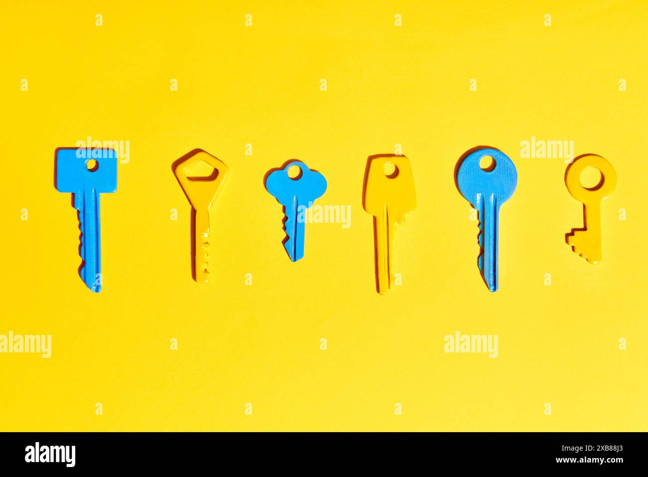 Various colorful keys on vibrant yellow background. Flat lay Stock ...