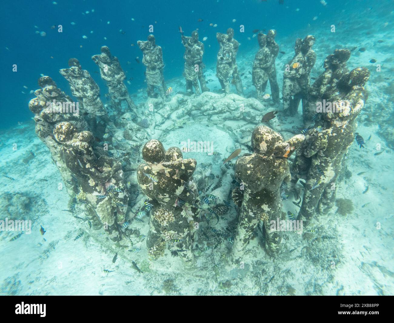 Statues on rocks by water with scuba gear Stock Photo - Alamy