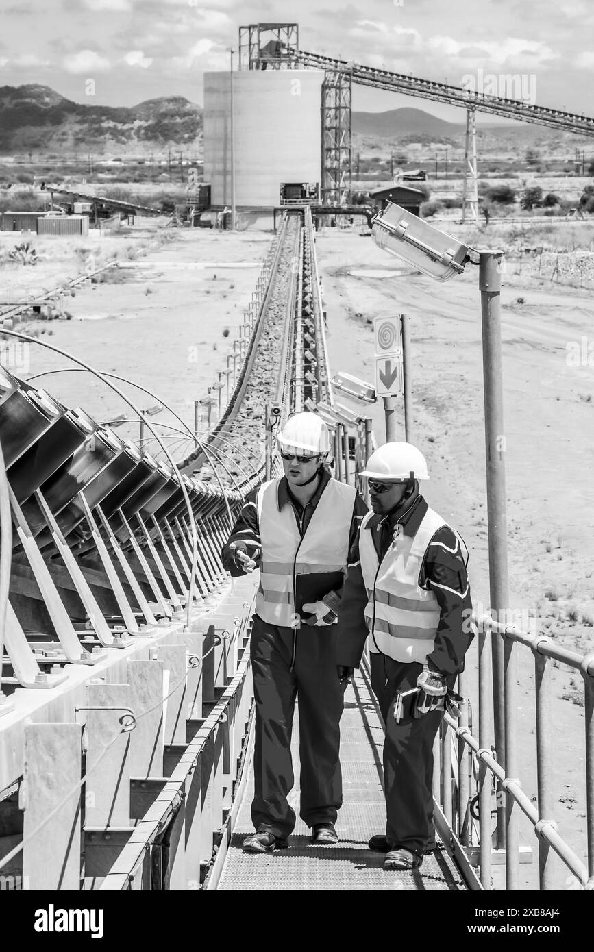 Two men in hard hats walking on train tracks Stock Photo - Alamy