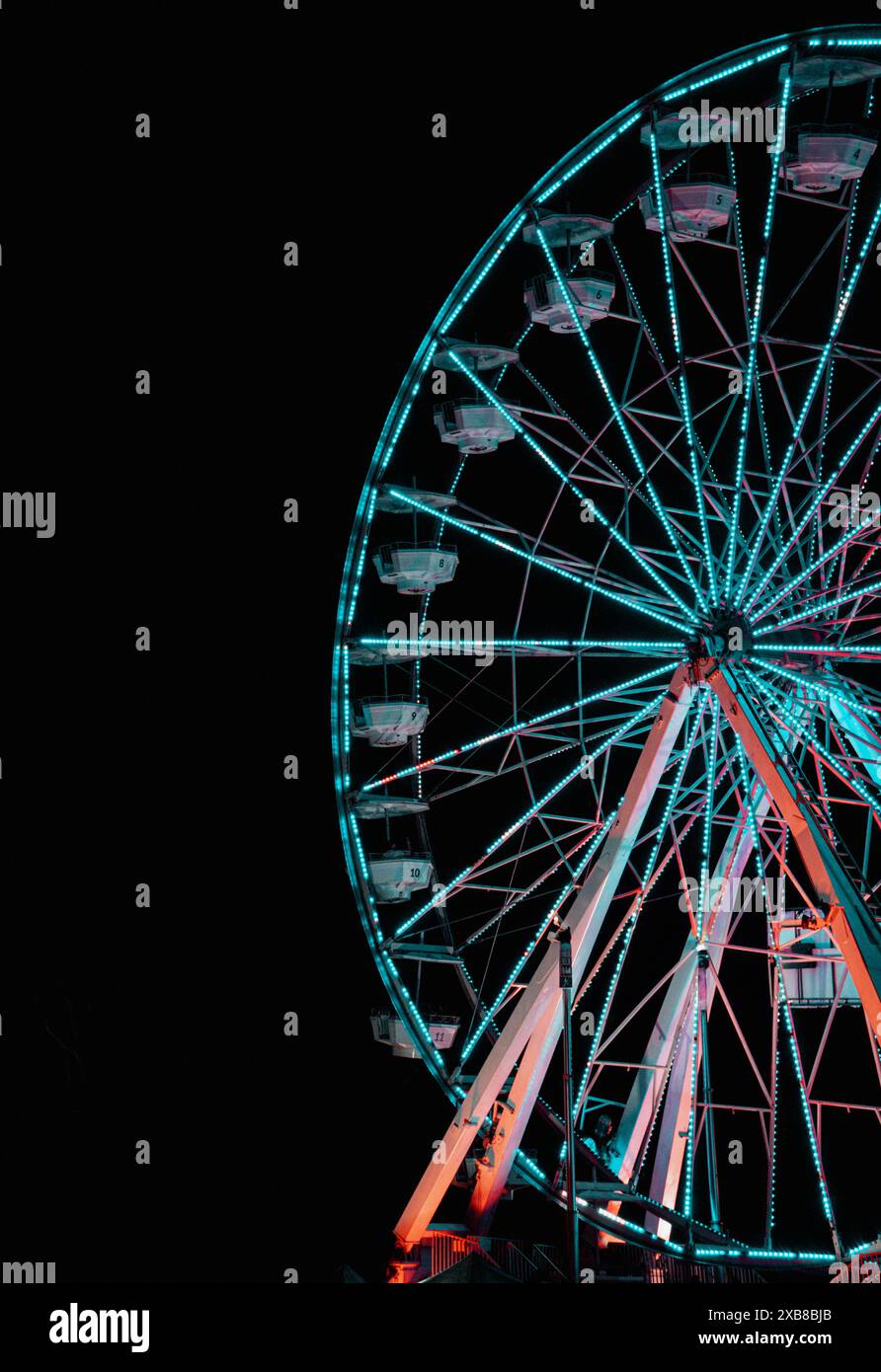 Glowing neon-lit blue ferris wheel in the dark Stock Photo - Alamy