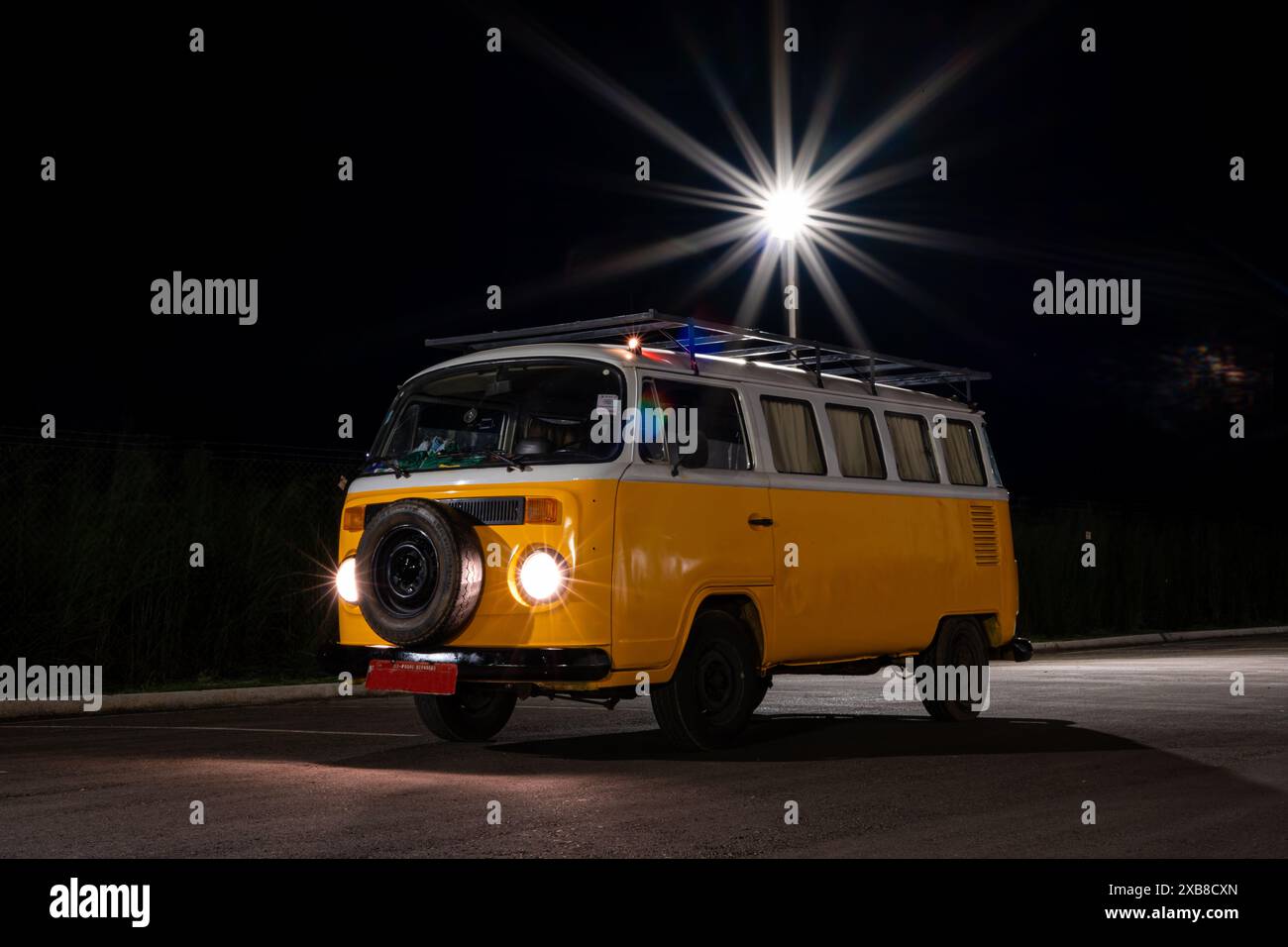 A camper van driving on road at night with bright headlights Stock ...