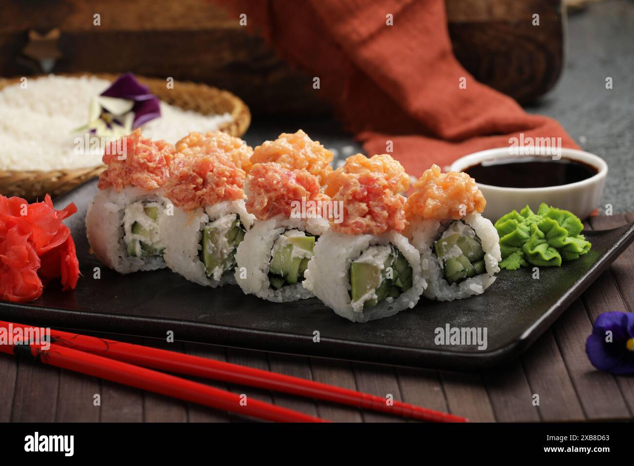 A shot of vegetable sushi roll with assorted veggies and a side of ...