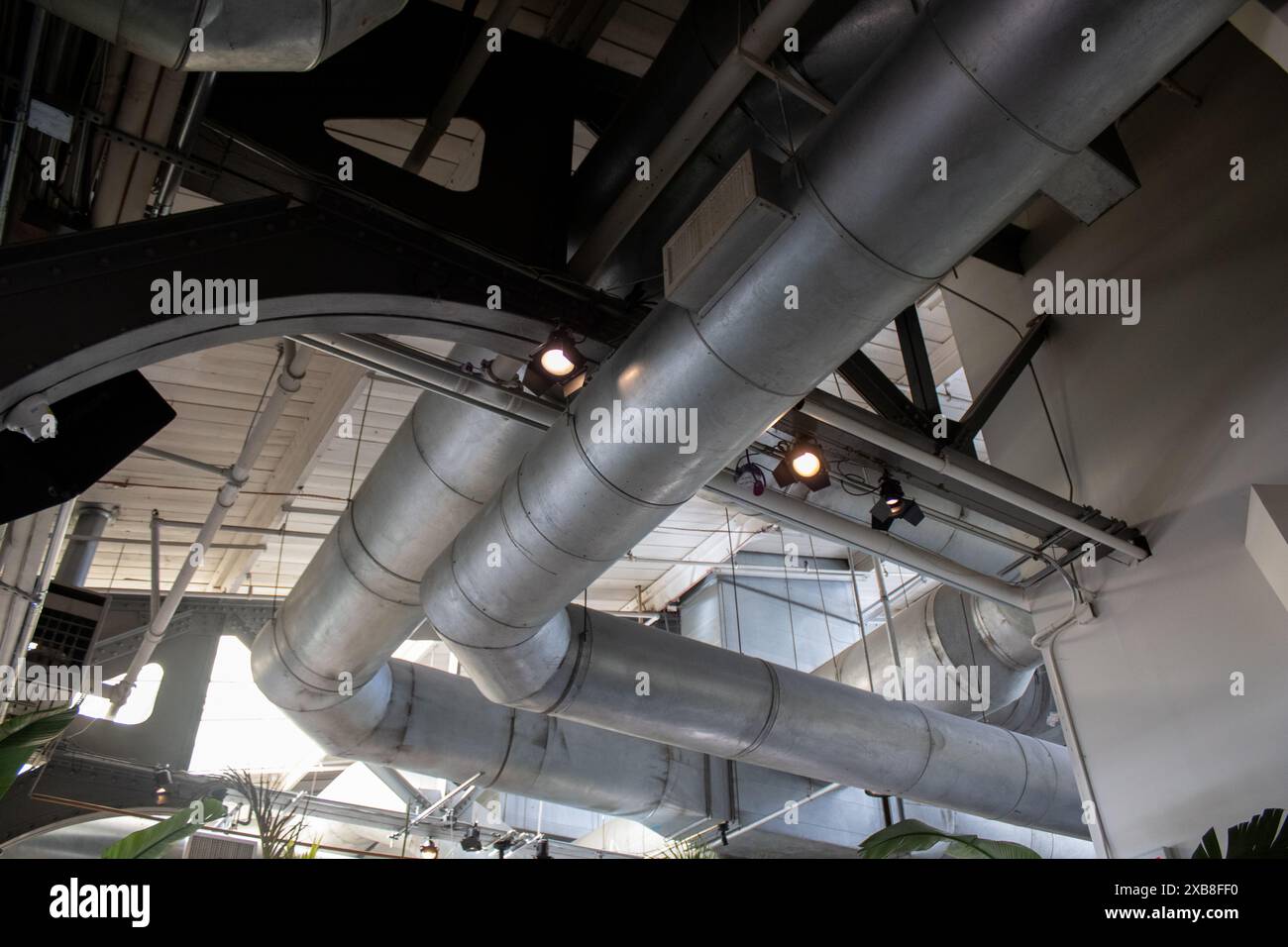 A low-angle shot of pipes and wires in a building, industrial ...