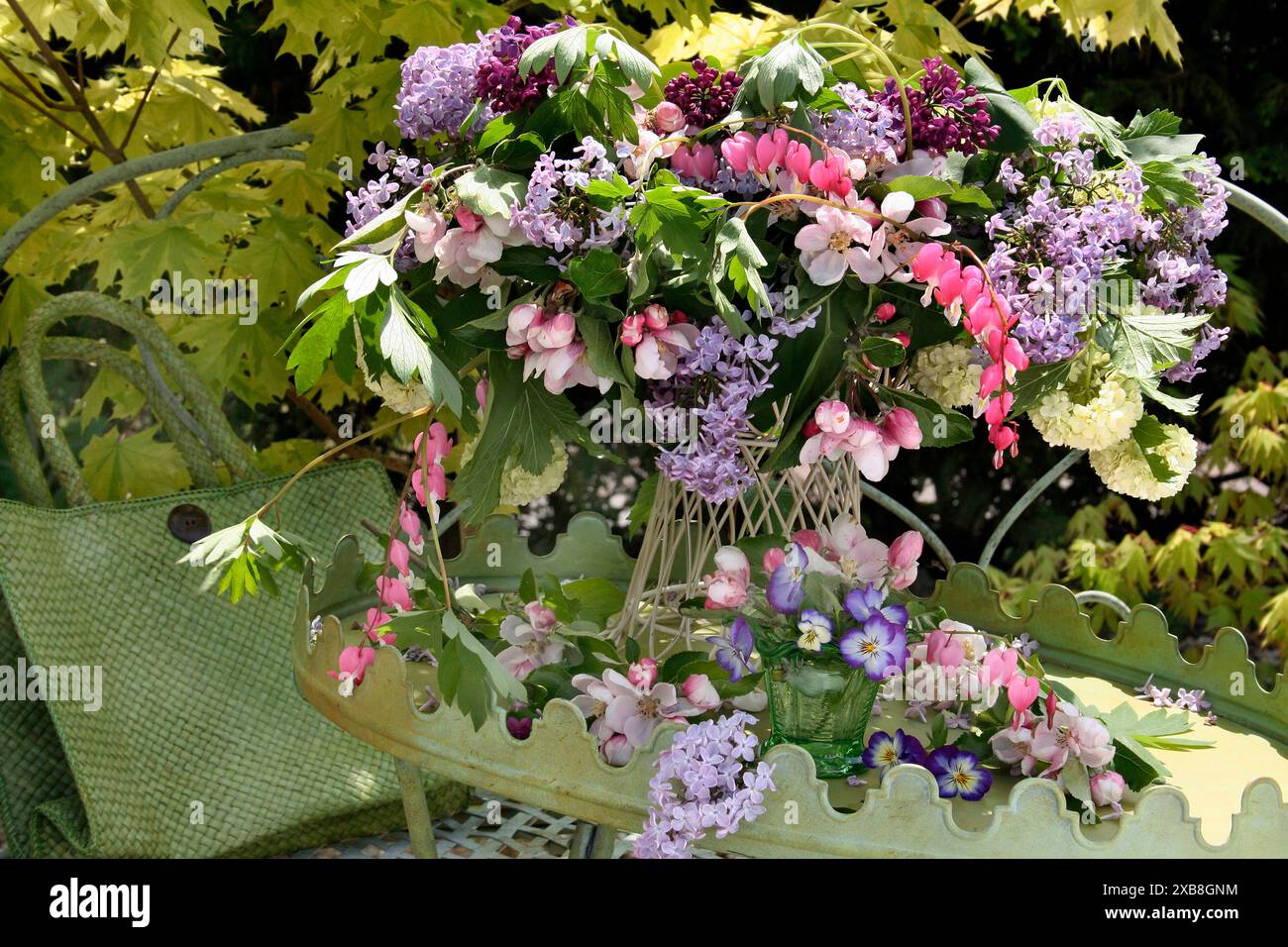 botany, syringa, pansies, dicentra and prunus in a wire basket on a ...