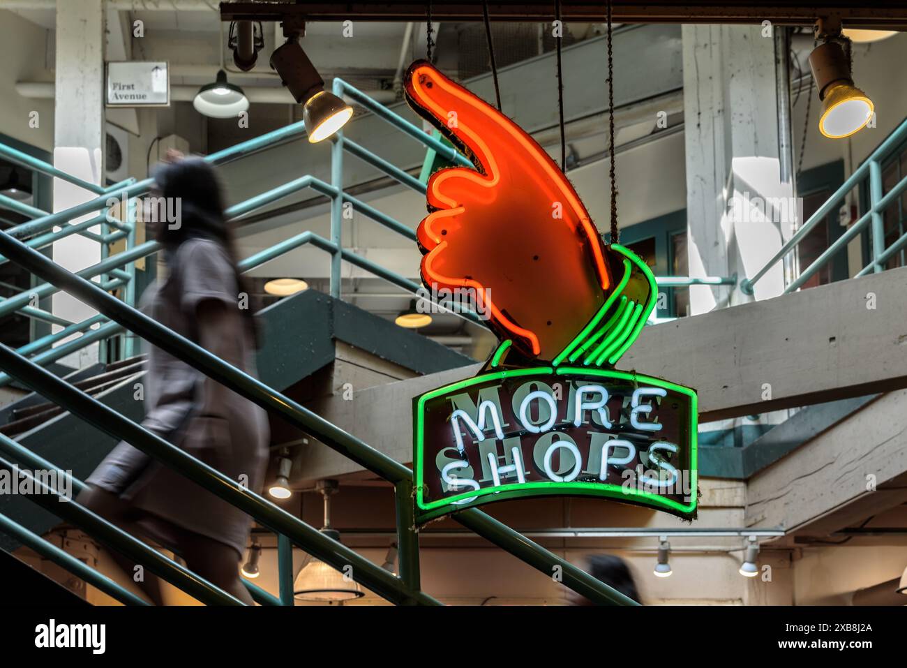 Neon sign of a big finger pointing upwards, with the text, 'more shops ...