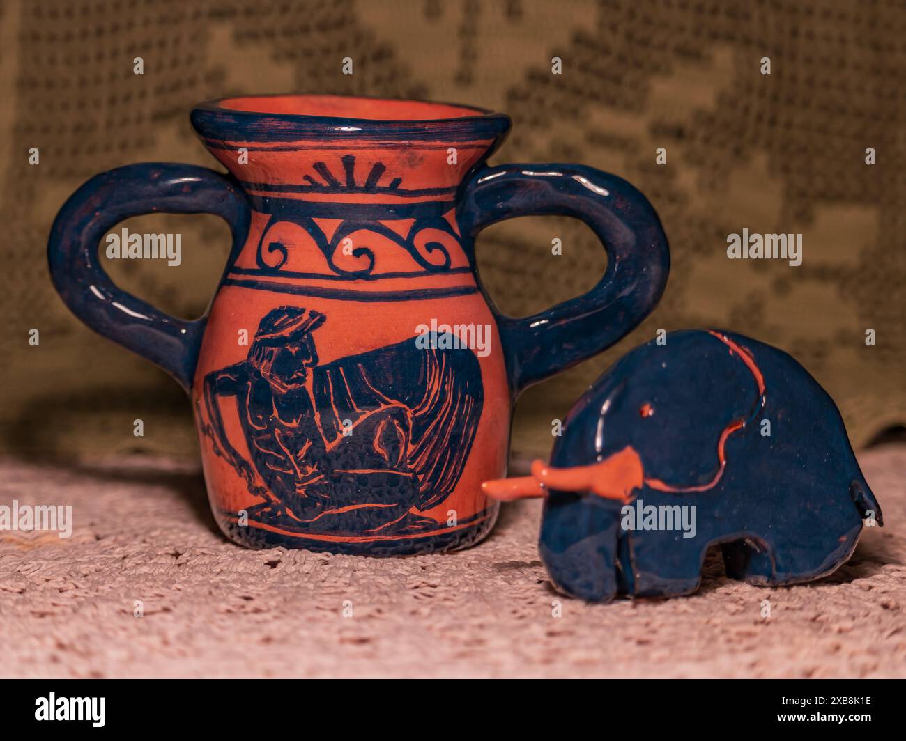 Greek-style ceramic jug with a blue elephant figurine Stock Photo - Alamy