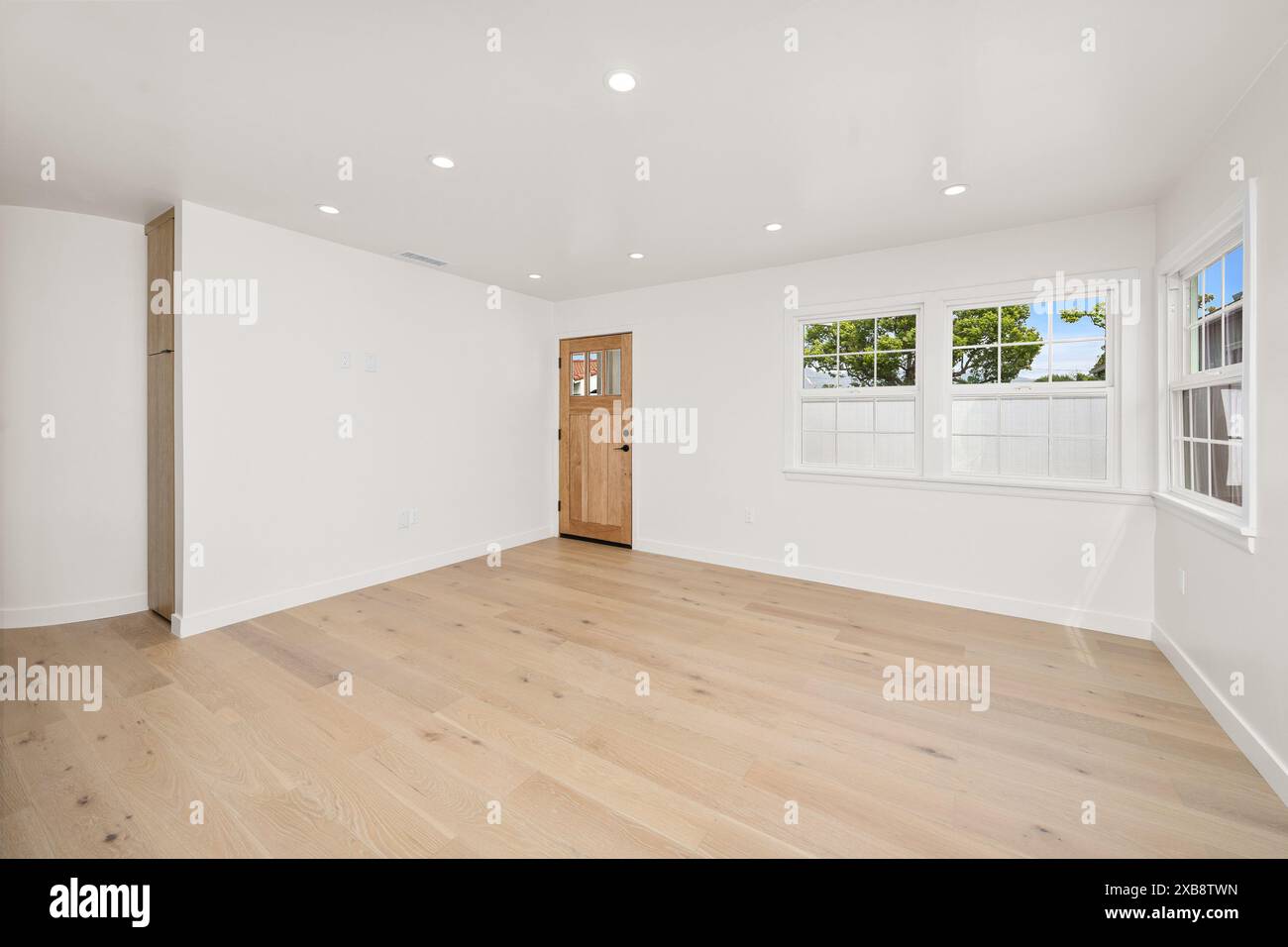 White-walled room with hardwood floors and windows Stock Photo - Alamy