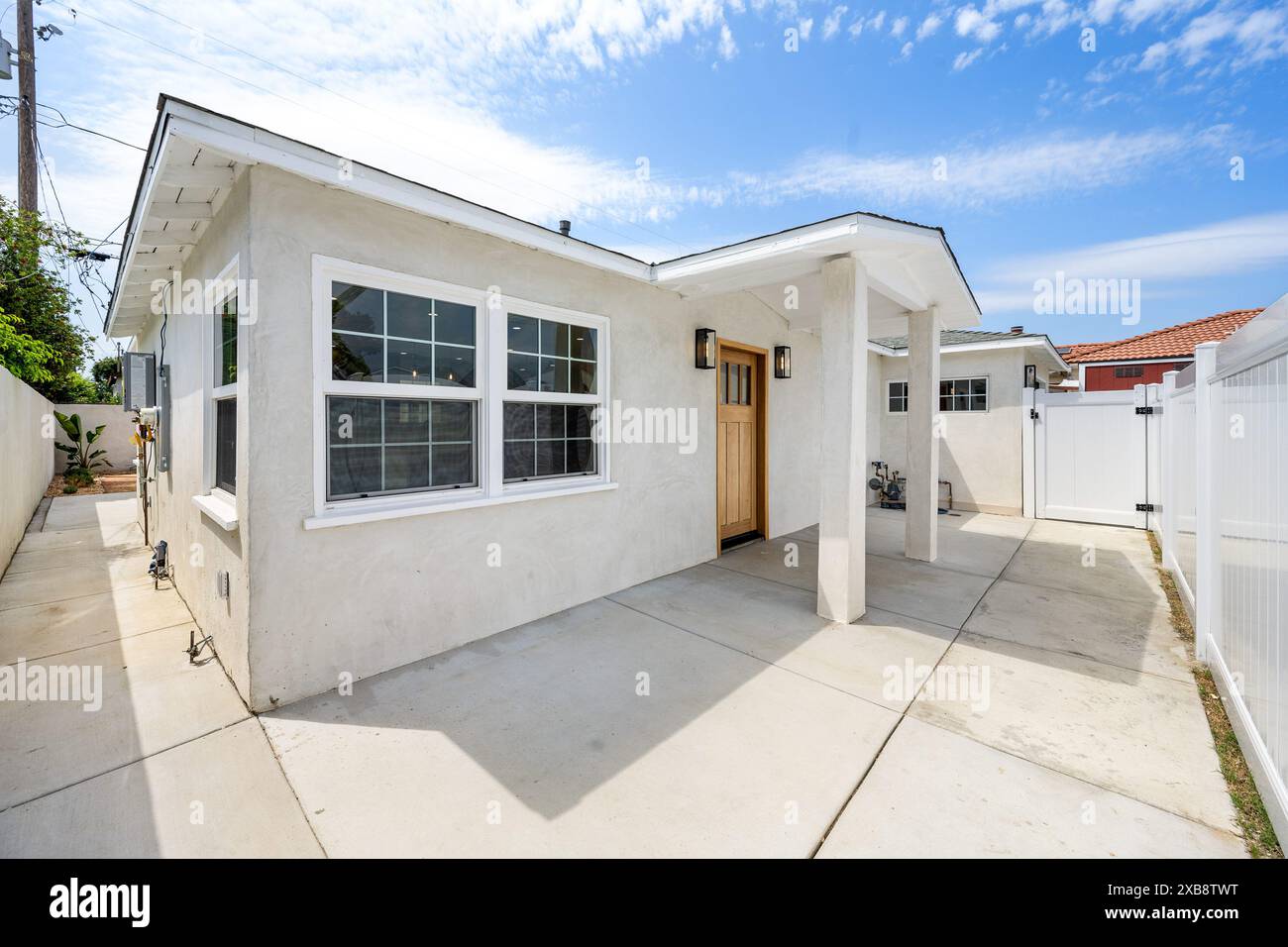 House with dual garages, fence, under a blue sky Stock Photo - Alamy