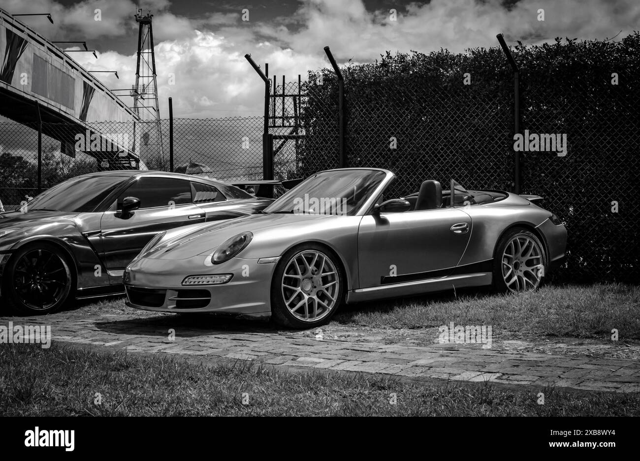 Two silver cars parked by a fence Stock Photo - Alamy
